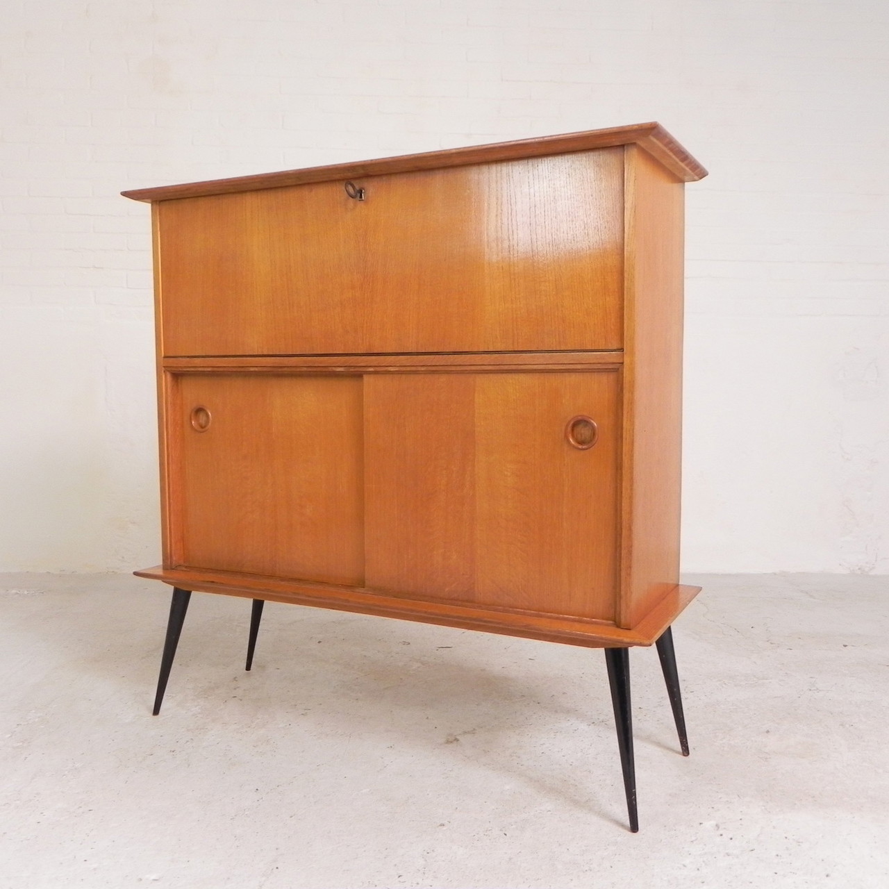 Secretaire with sliding doors on slender legs, 1950s | €595 | Whoppah